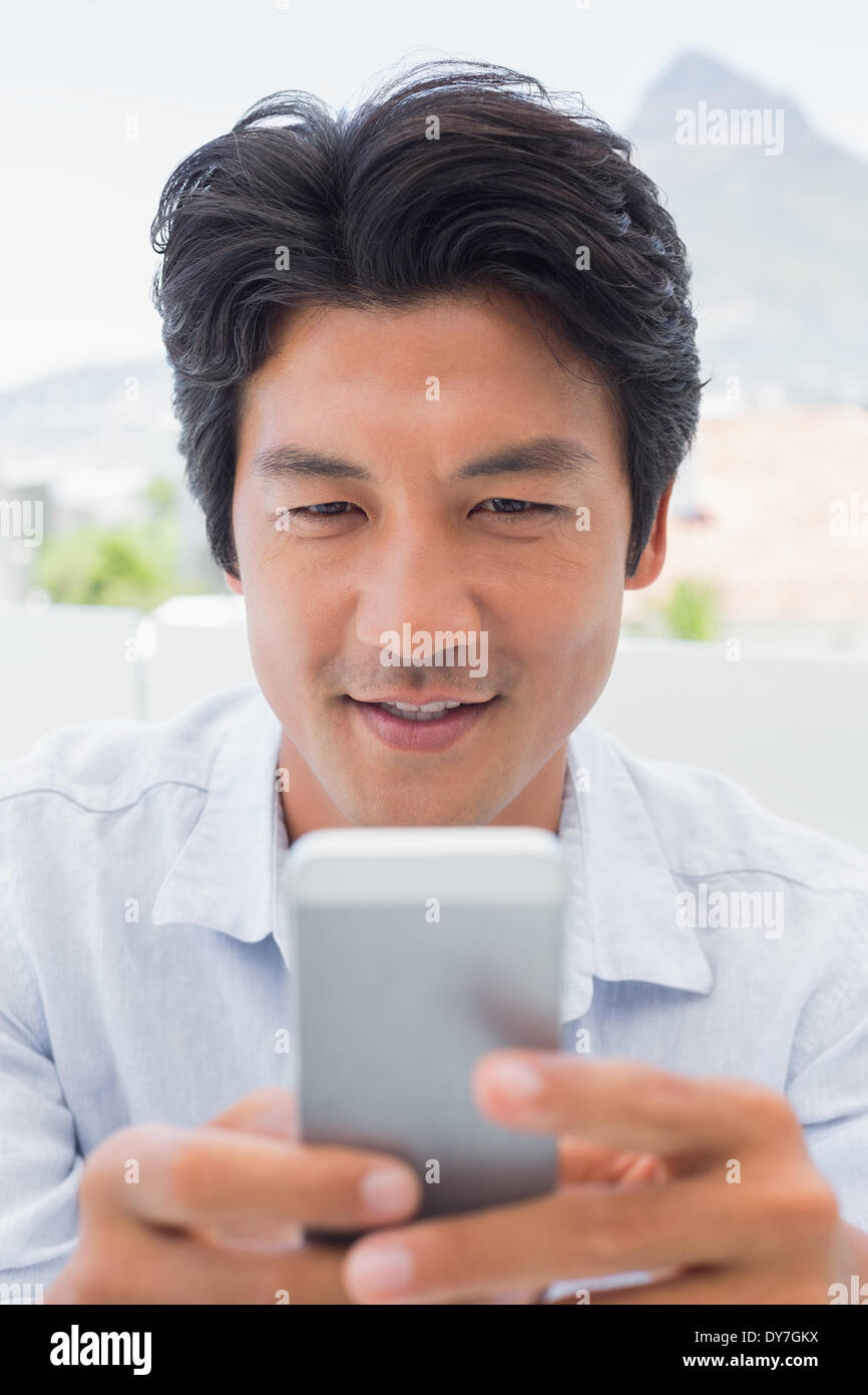 Happy casual man sending a text message Stock Photo - Alamy
