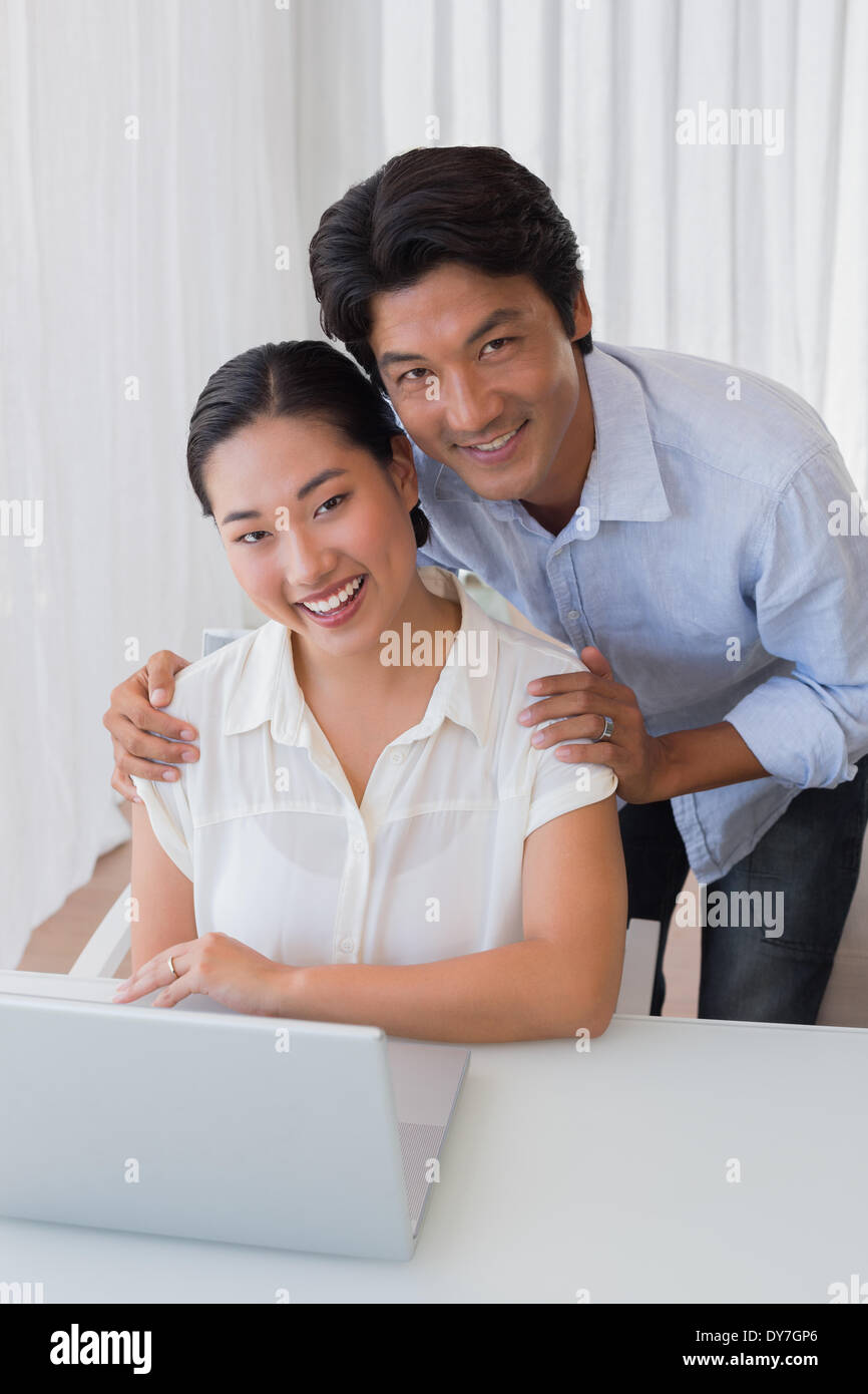 Happy couple using laptop together Stock Photo - Alamy