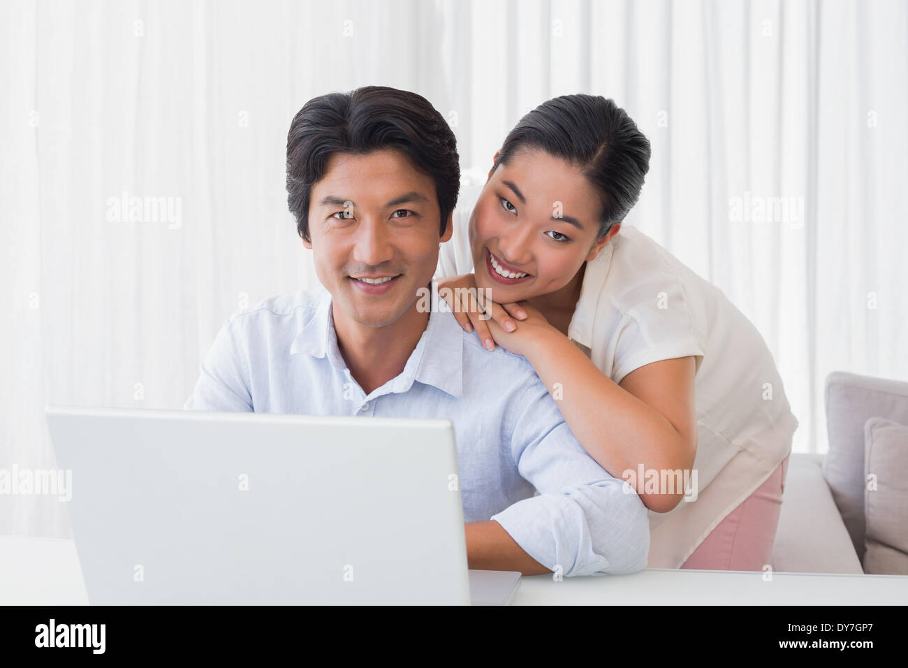 Portrait of a happy couple using laptop in the kitchen at home Stock ...