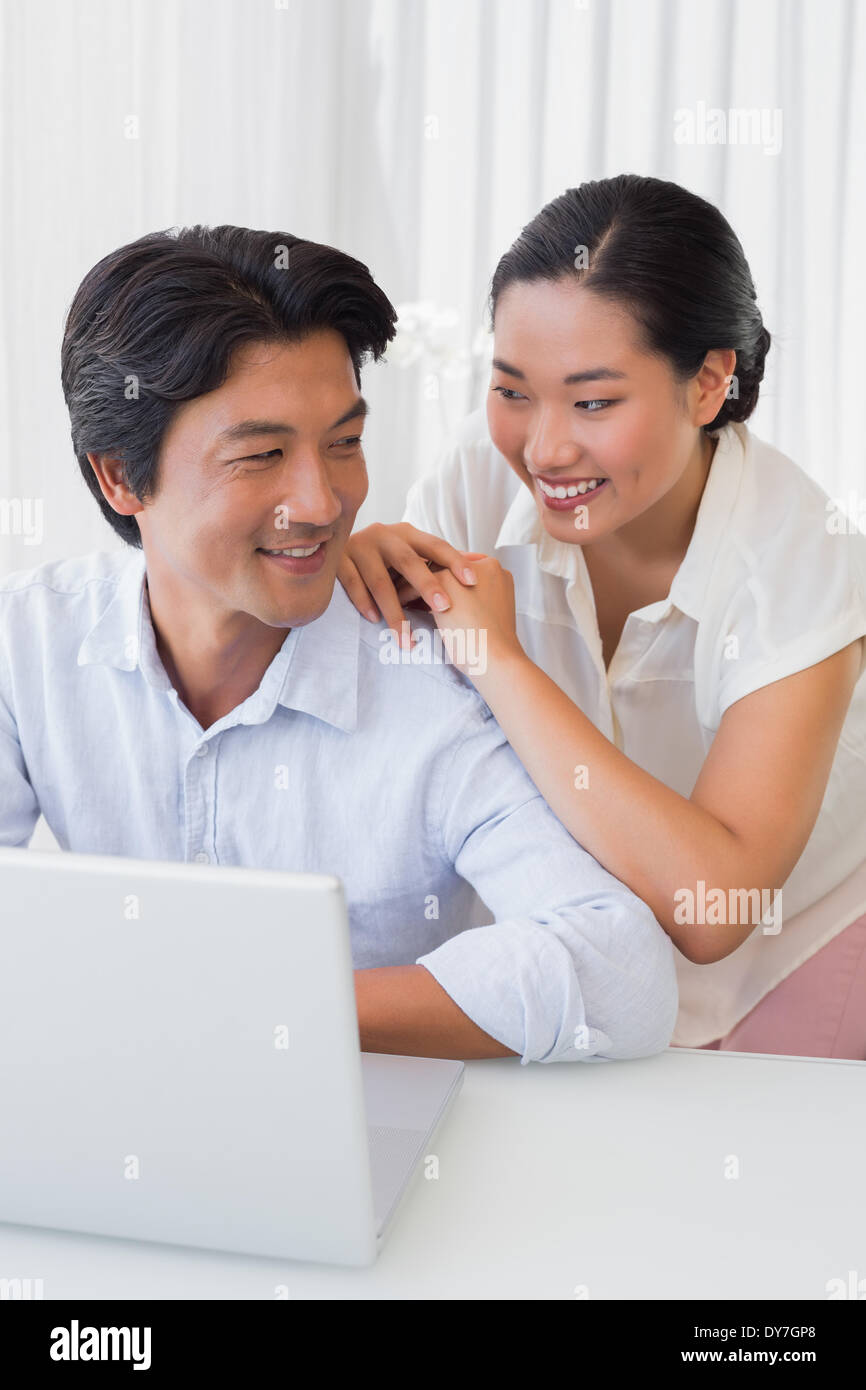 Happy couple using laptop together Stock Photo - Alamy
