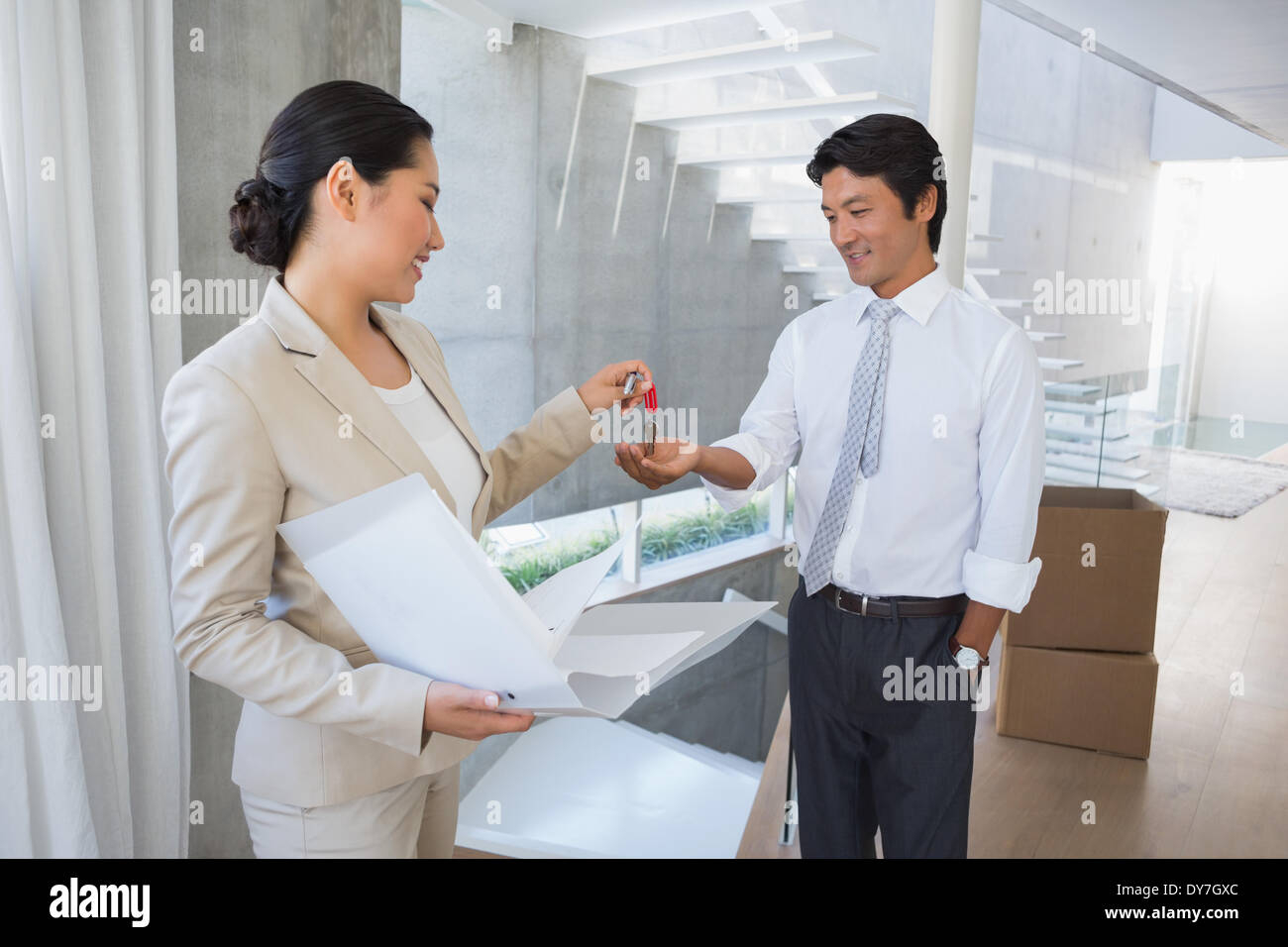 Estate agent giving house key to buyer Stock Photo - Alamy