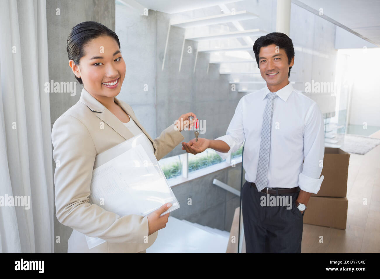 Estate agent giving house key to buyer Stock Photo - Alamy