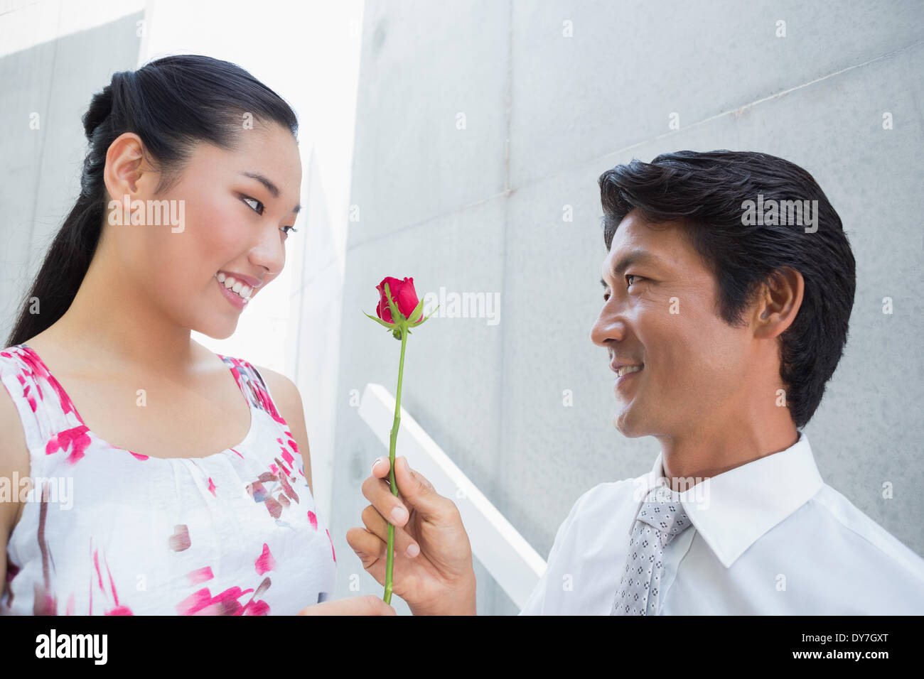 Man offering a red rose to girlfriend Stock Photo - Alamy
