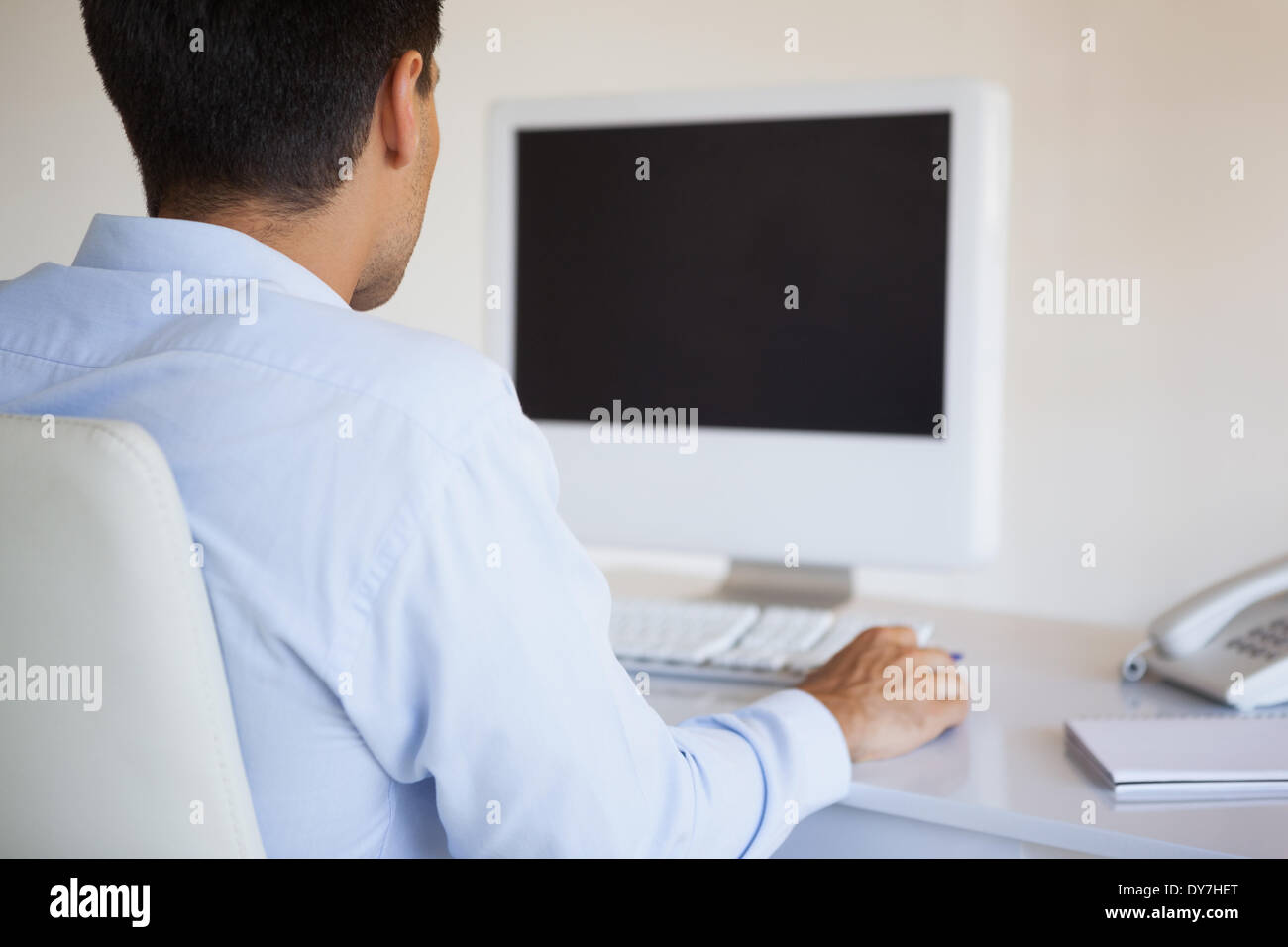 Casual businessman using computer at his desk Stock Photo - Alamy