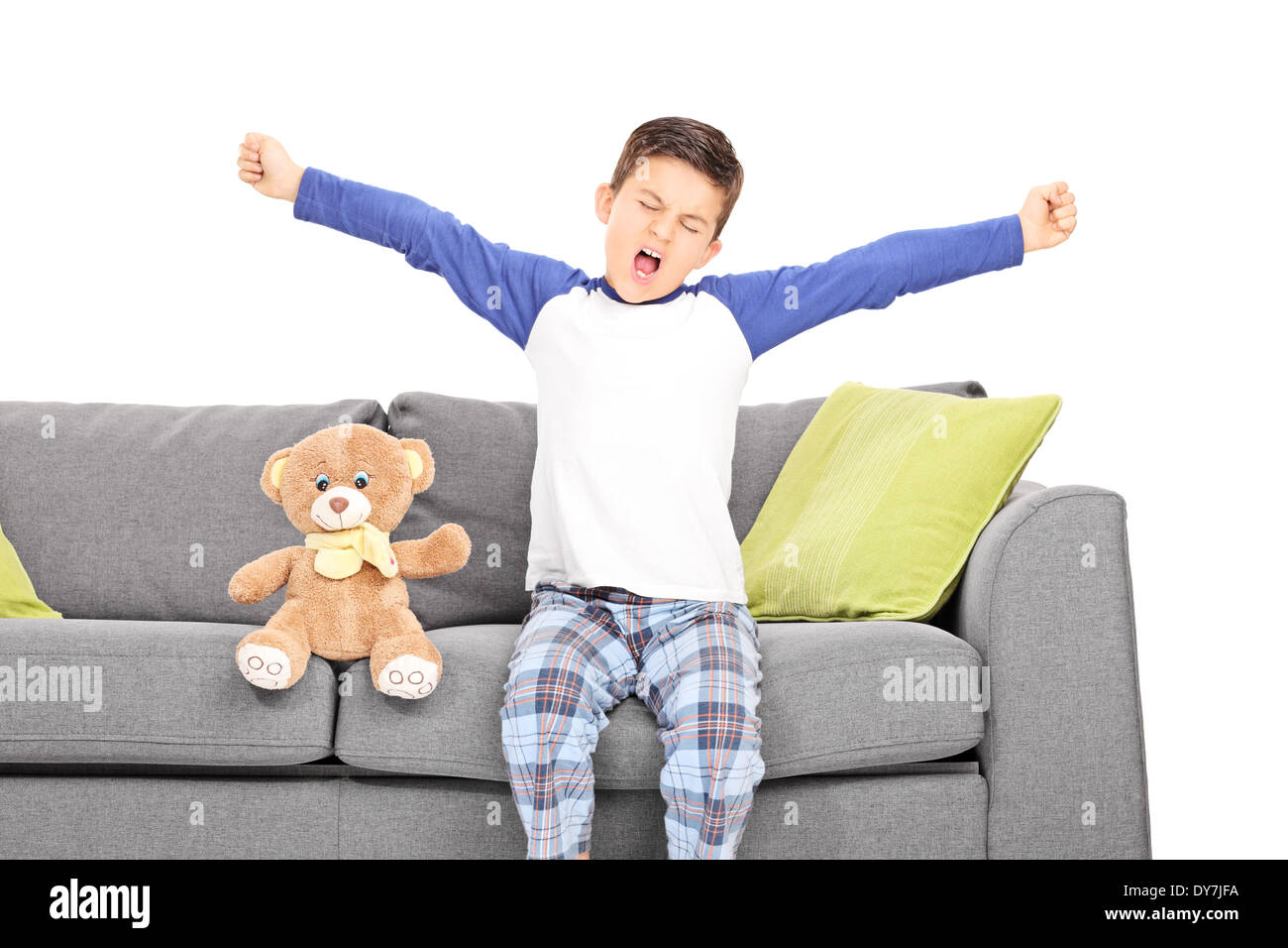 Little boy yawning seated on couch Stock Photo - Alamy