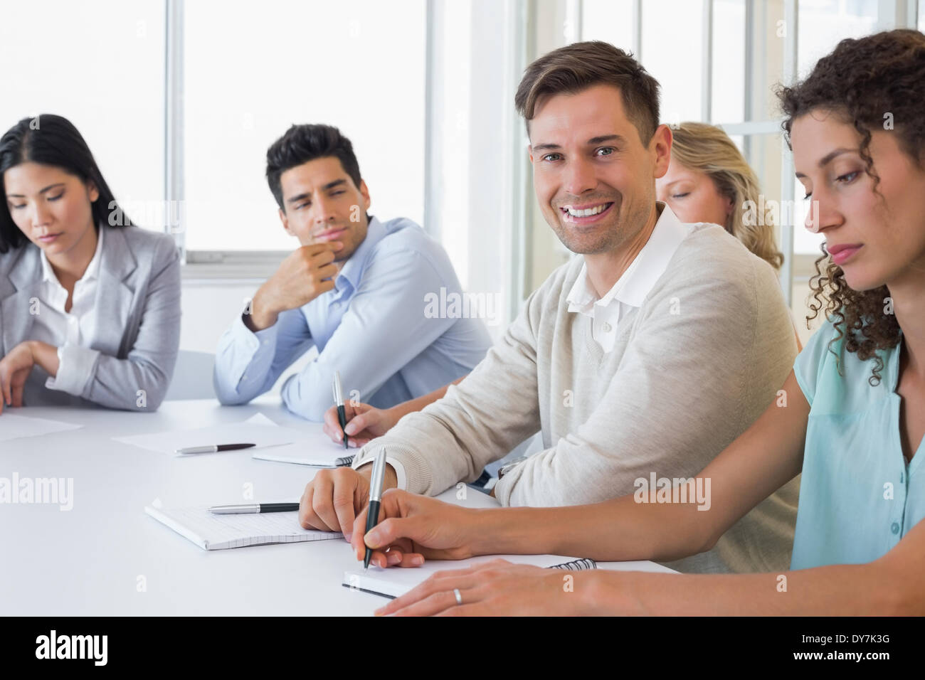 Casual businessman smiling at camera during meeting Stock Photo - Alamy
