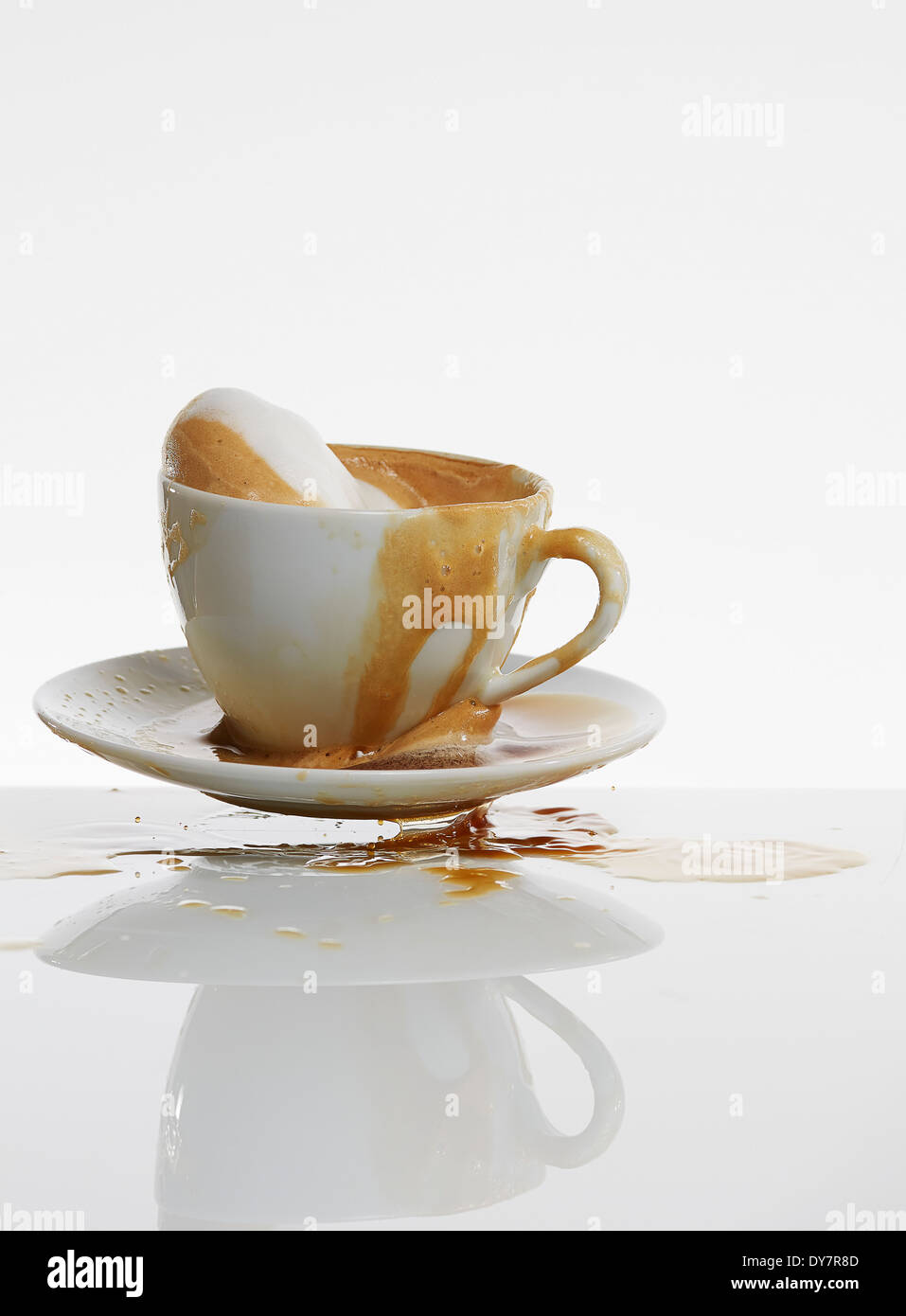White coffee splashing out of coffee cup in front of white background ...