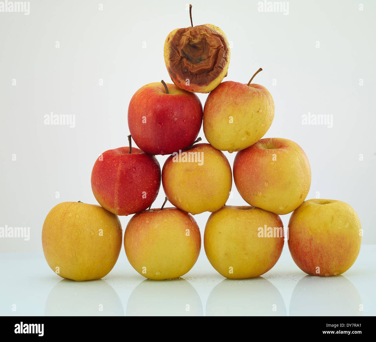 Pyramid of apples with a frotten one on top Stock Photo - Alamy