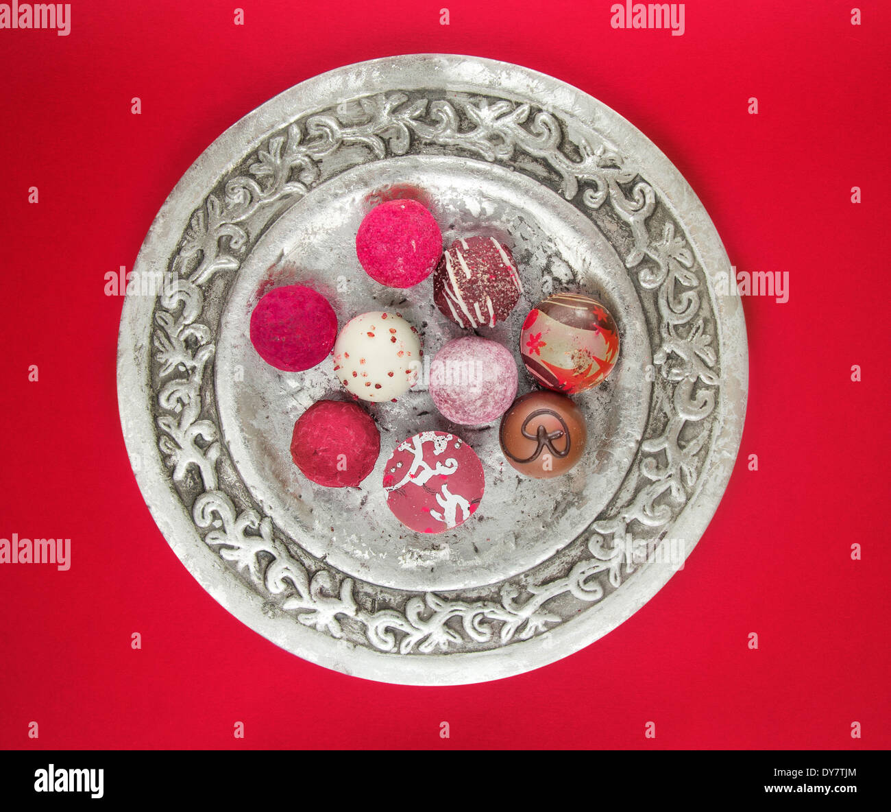 silver plate with colorful pralines on red Stock Photo - Alamy