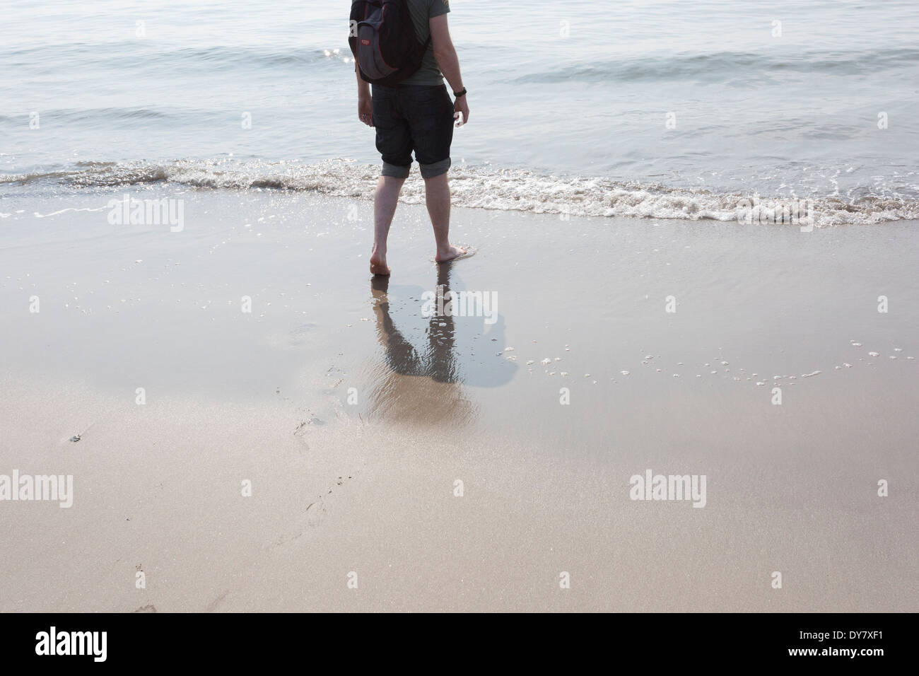 Man walking in to water on Sandy Beach Stock Photo - Alamy