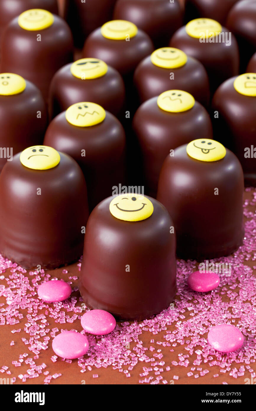 Chocolate marshmallows decorated with different smiley faces, pink ...