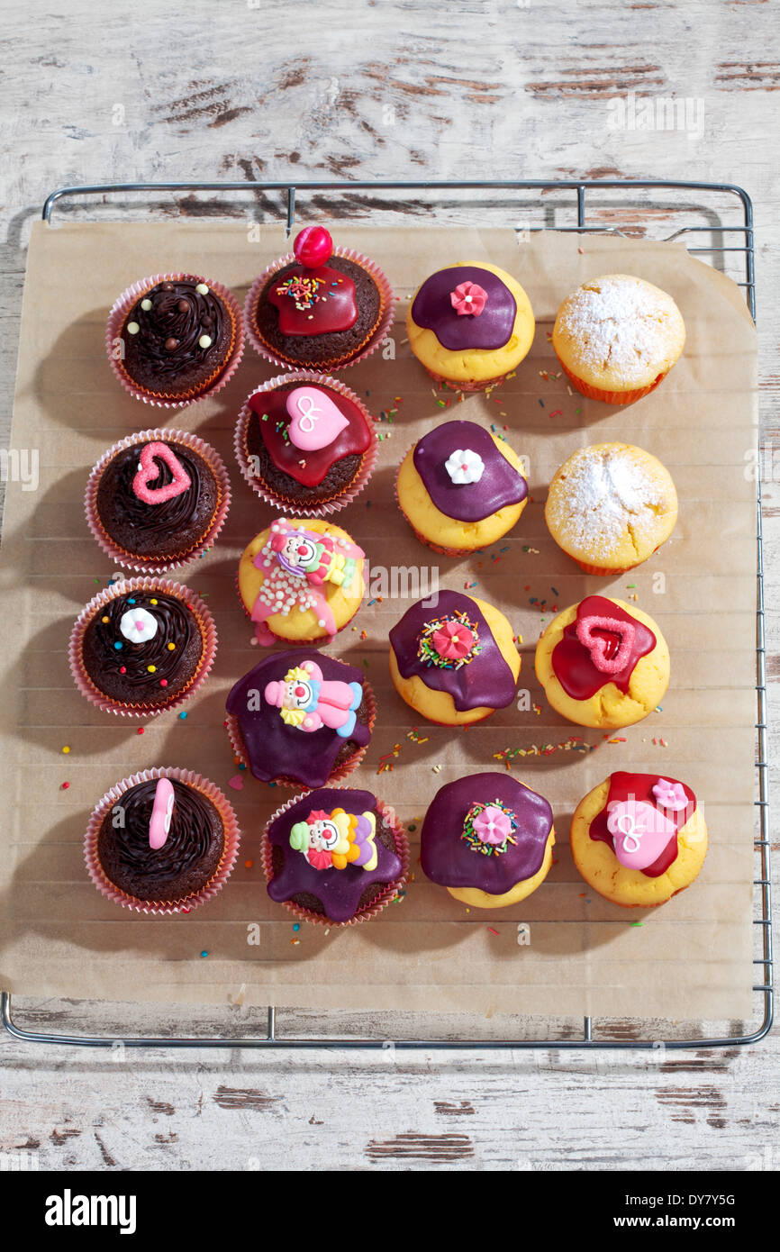 Decorated muffins in muffin papers on cooling grid, elevated view Stock ...