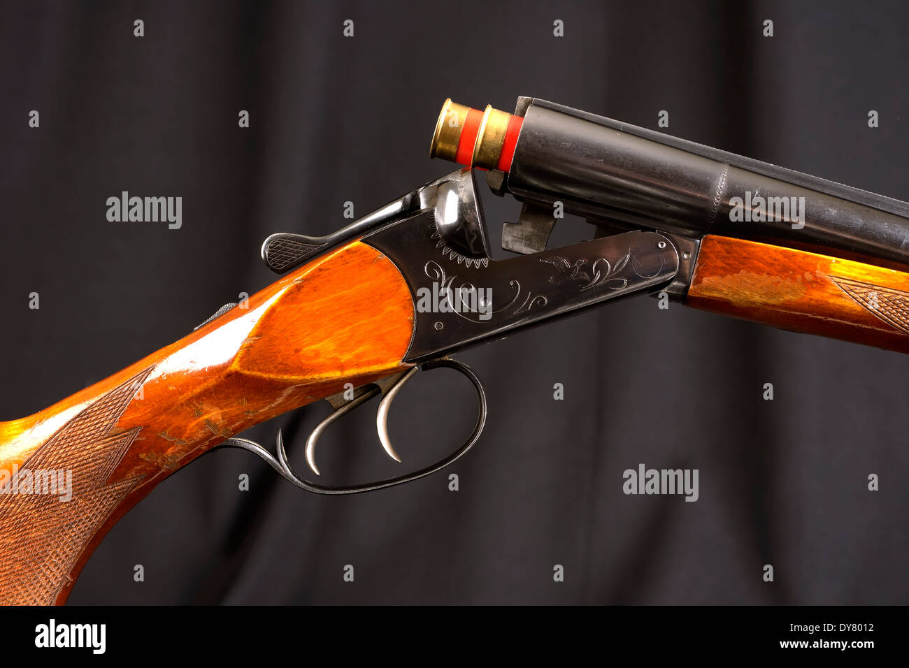 Opened double-barreled hunting gun with two cartridges against black ...