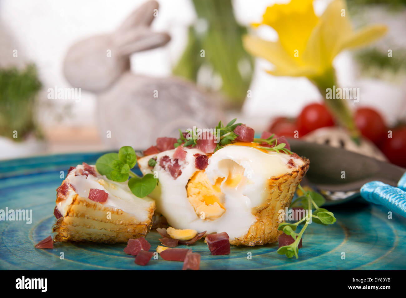 Egg muffin with ham cubes on plate and Easter bunny in background Stock ...