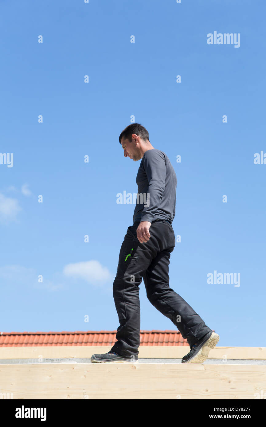 Construction of a residential house, man walking on wooden beam Stock ...