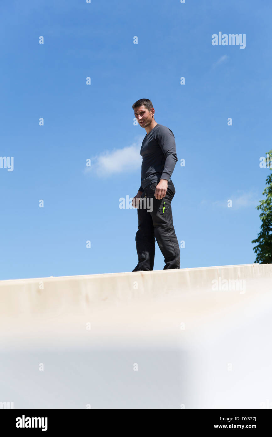 Construction of a residential house, man standing on roof Stock Photo ...