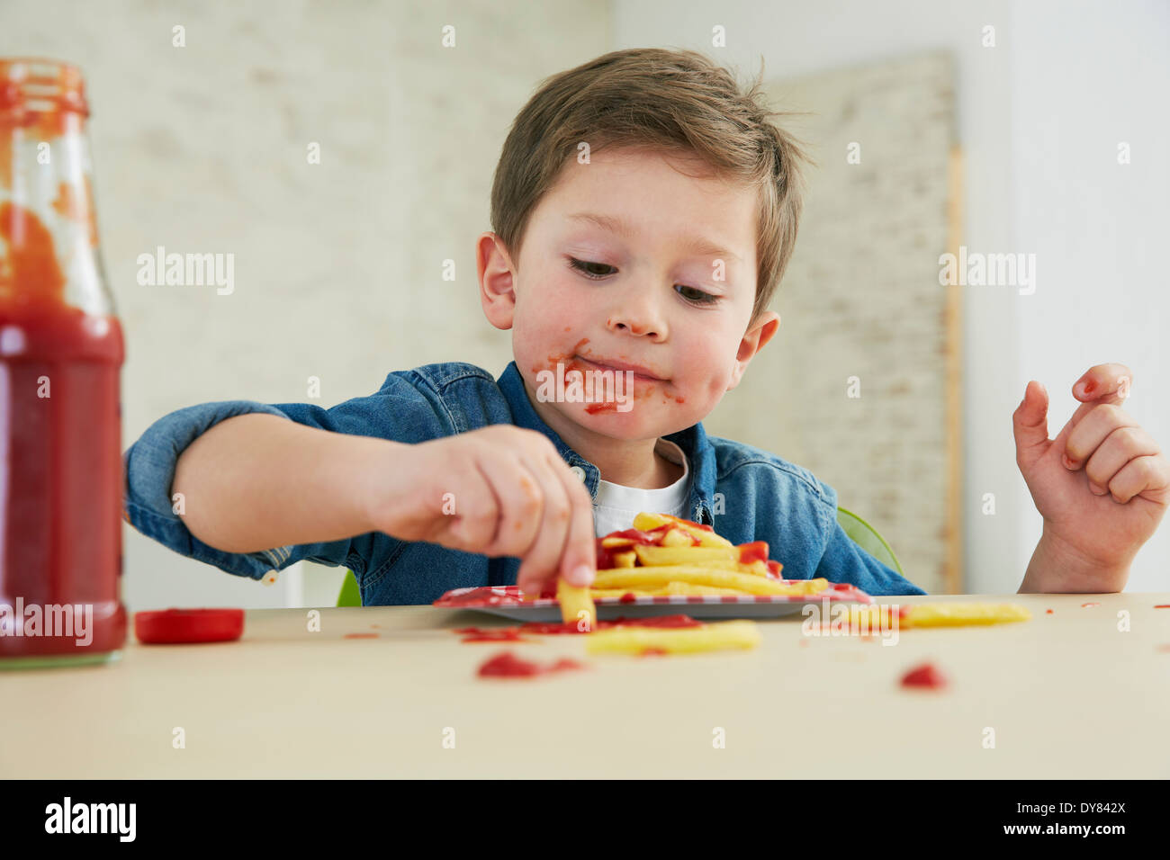 Germany, Munich, Boy eating French fries with ketchup Stock Photo - Alamy