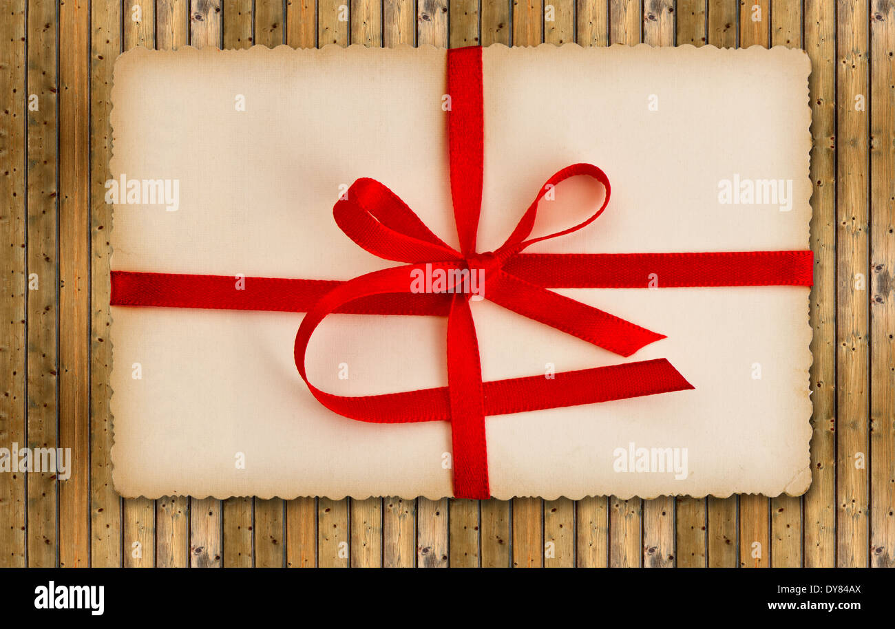 vintage gift card with red ribbon on wooden background Stock Photo - Alamy