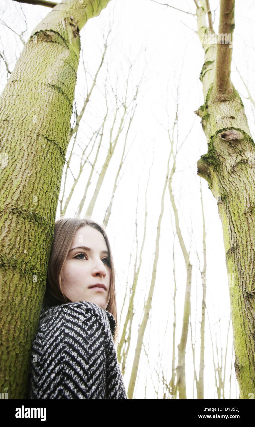 Portrait of teenage girl leaning against tree trunk Stock Photo - Alamy