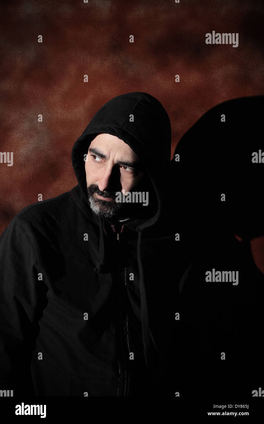 a hooded man looking back Stock Photo - Alamy