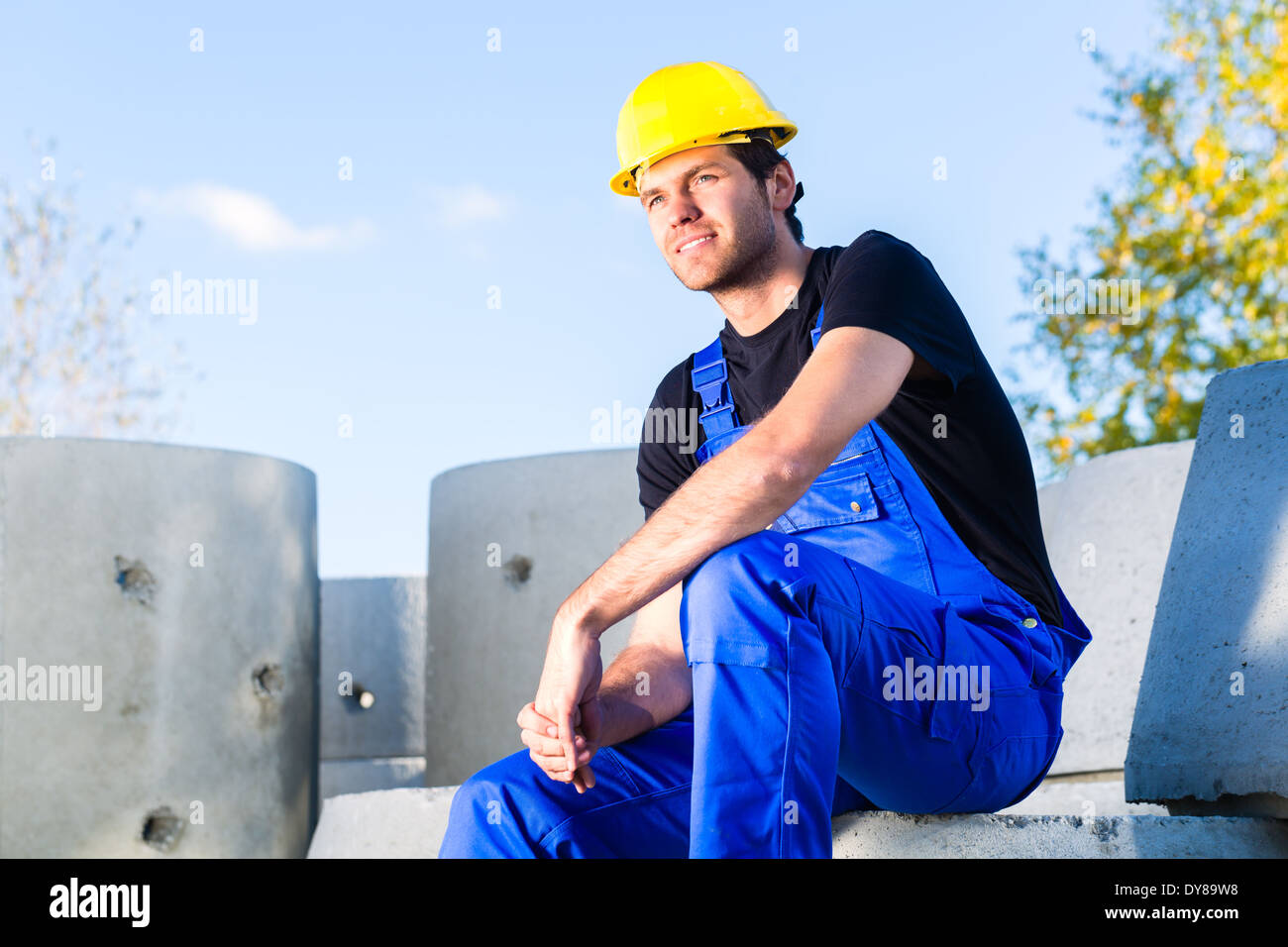 Proud builder standing on construction or building site with sewage or ...