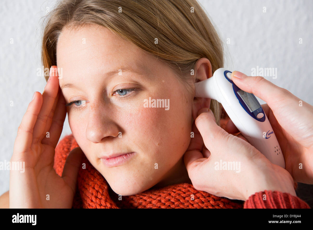 Young woman lying in bed, has a cold, fever, flu, fever, measured with ...