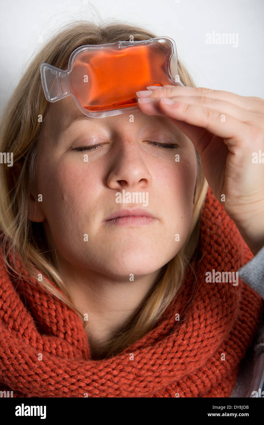 Young woman has a cold, warm up with a heat pack Stock Photo - Alamy