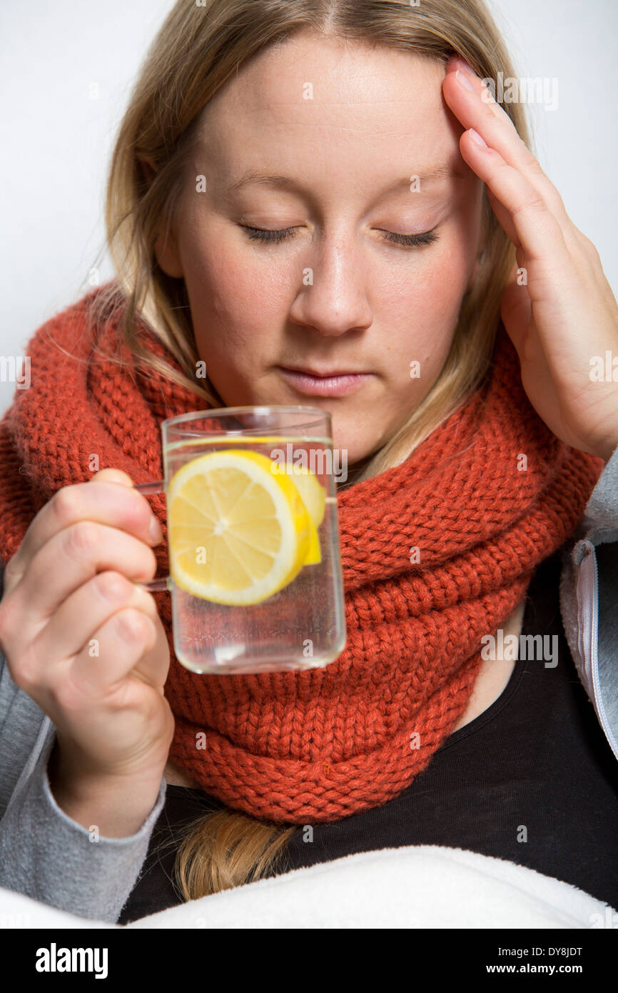 Young woman has a cold, fever, flu, drinking a hot lemon Stock Photo ...