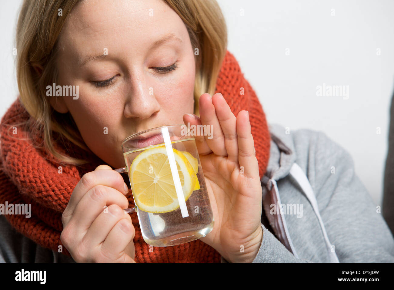 Young woman has a cold, fever, flu, drinking a hot lemon Stock Photo ...