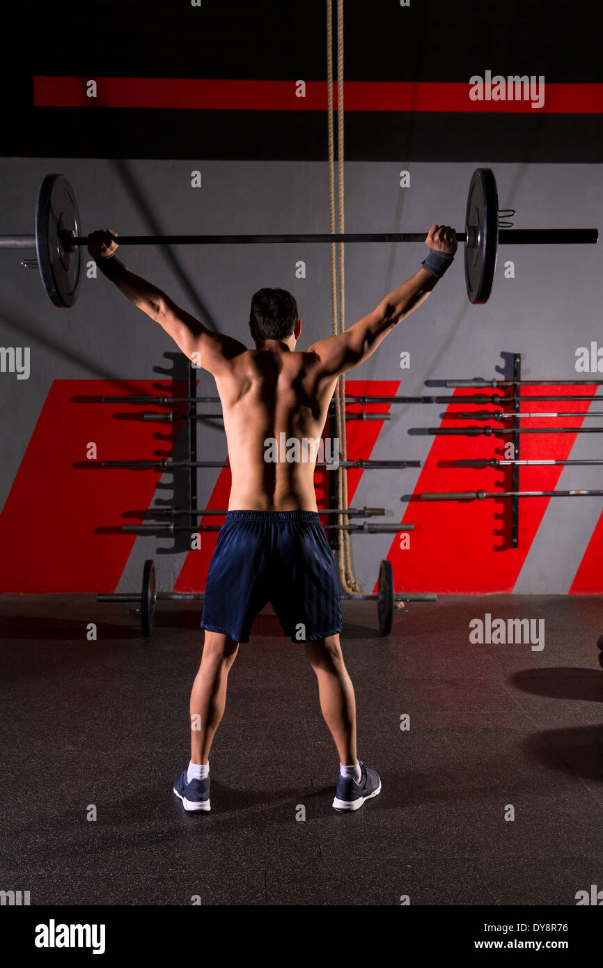 barbell weight lifting man rear view back workout exercise at gym box ...