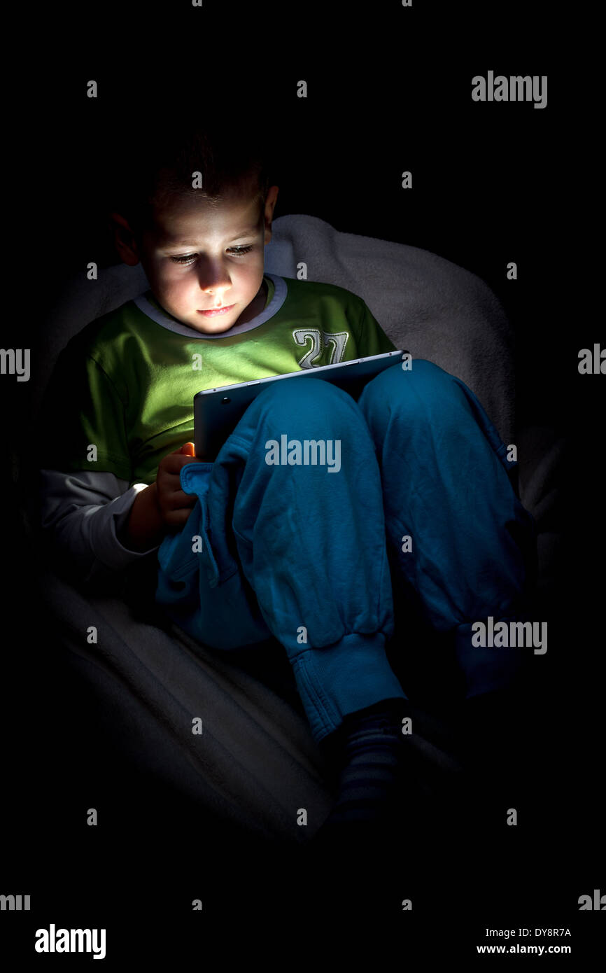 Boy very carefully looking at the tablet Stock Photo - Alamy