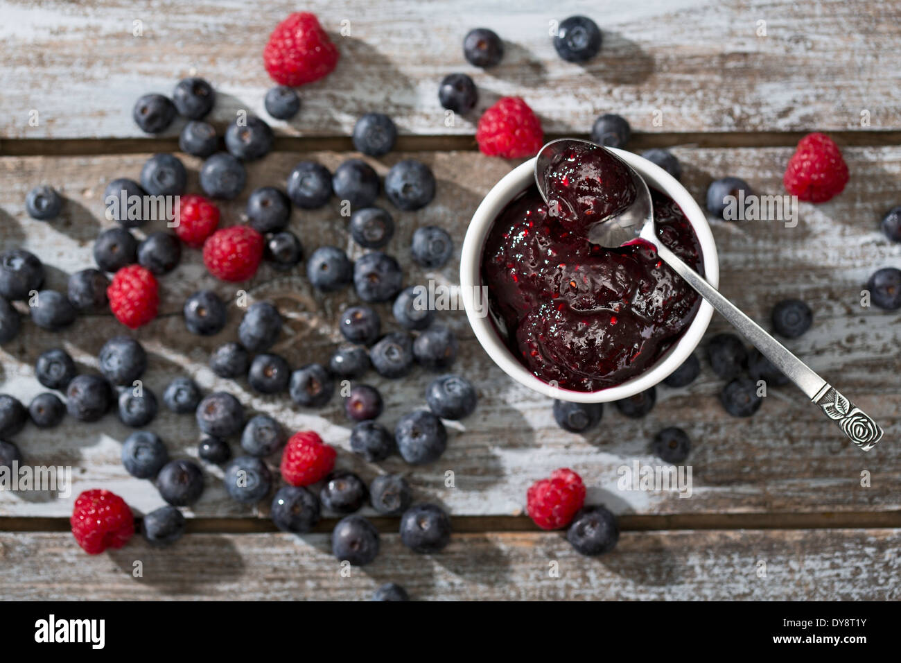 Bowl of blueberry and raspberry jam, spoon, raspberries and blueberries ...