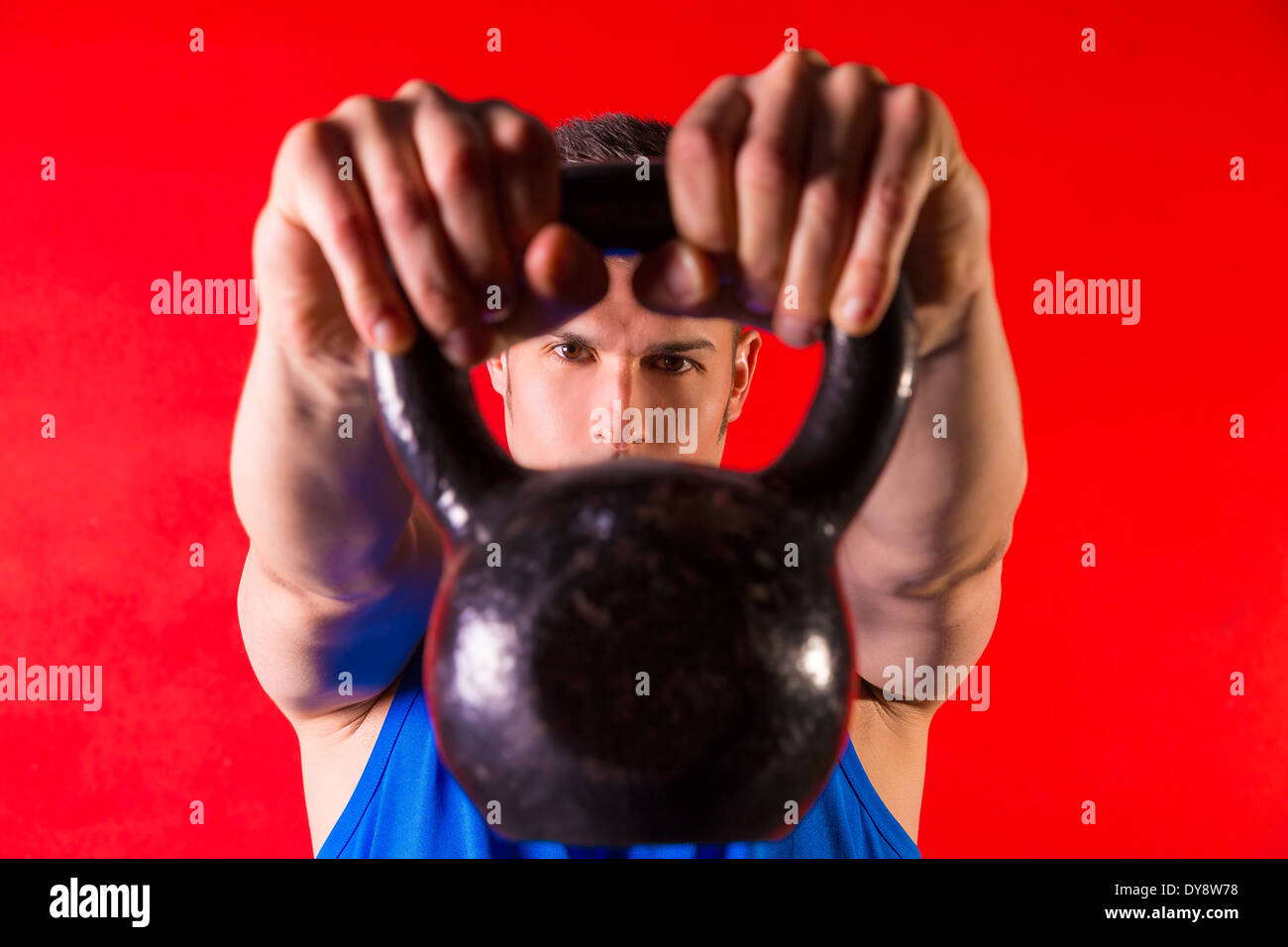 Kettlebell man portrait looking through the handle ring at gym workout ...