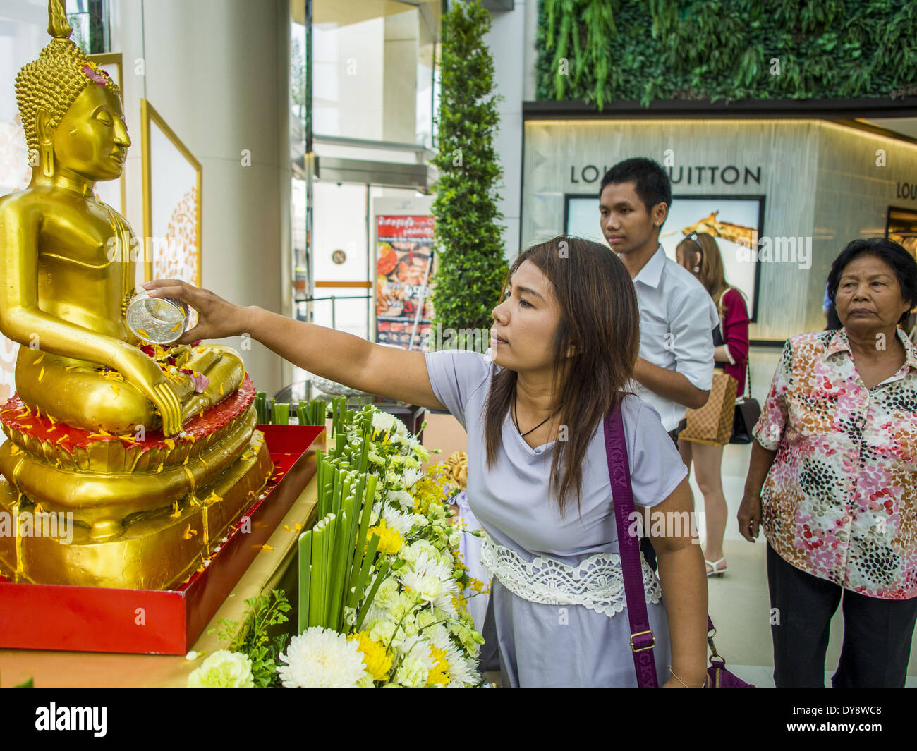 Bangkok, Thailand. 10th Apr, 2014. A Thai Buddhist bathes a Buddha ...