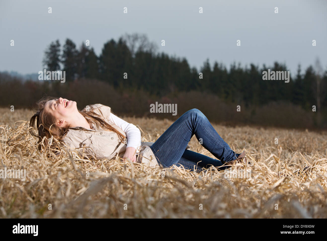 Portrait of laughing teenage girl lying on field Stock Photo - Alamy