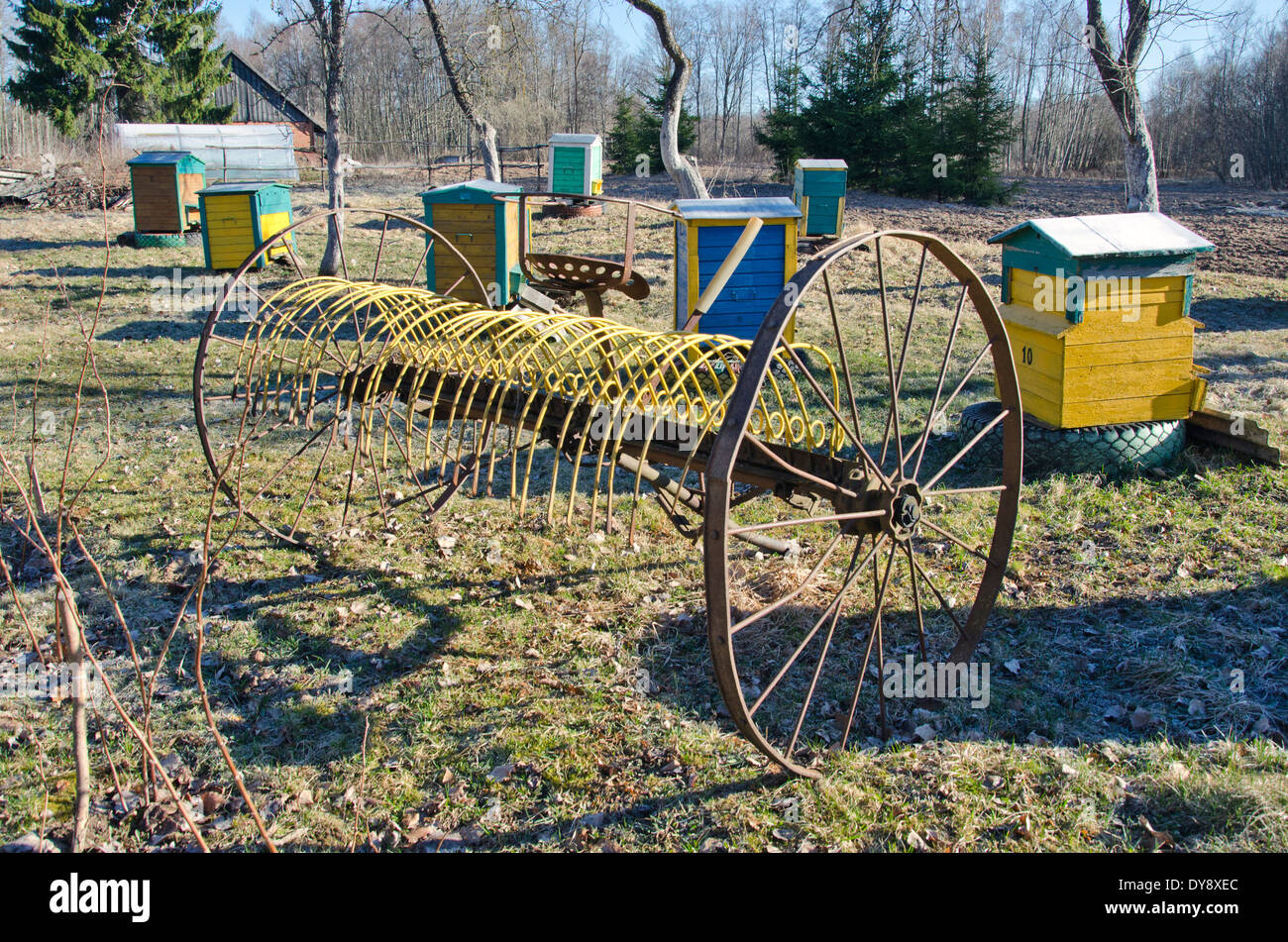 antique horse-drawn rake and colorful beehive in farm garden Stock ...