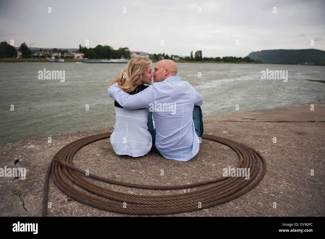 Germany, Rhineland-Palatinate, young couple kissing at waterside of ...