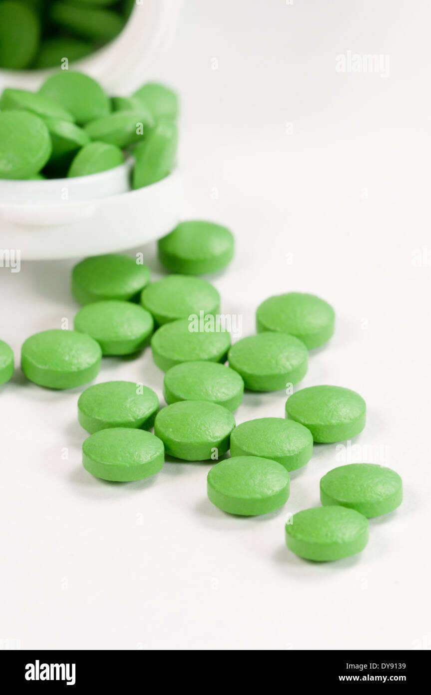 Green tablets near the box over light background Stock Photo - Alamy