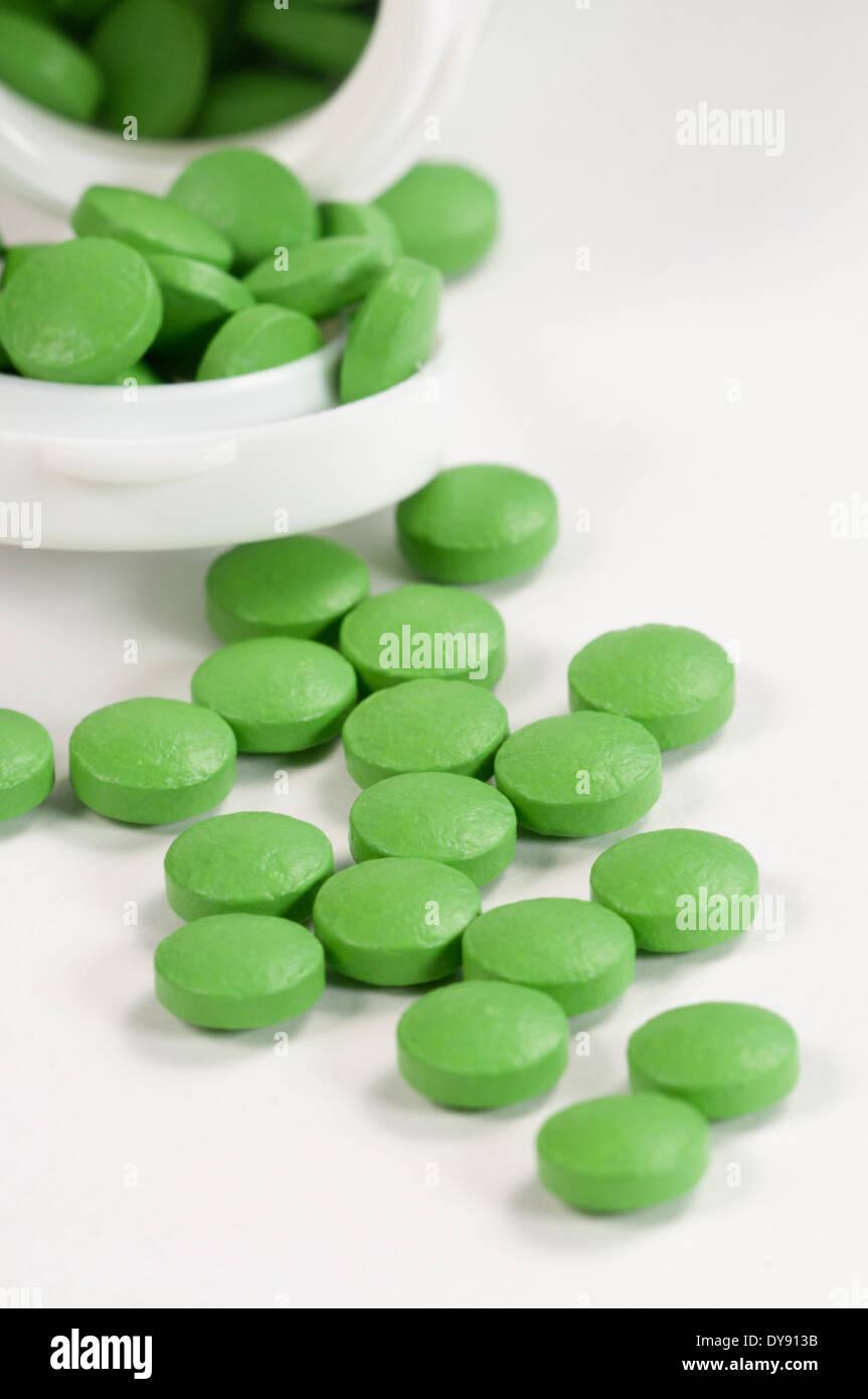 Green tablets near the box over light background Stock Photo - Alamy