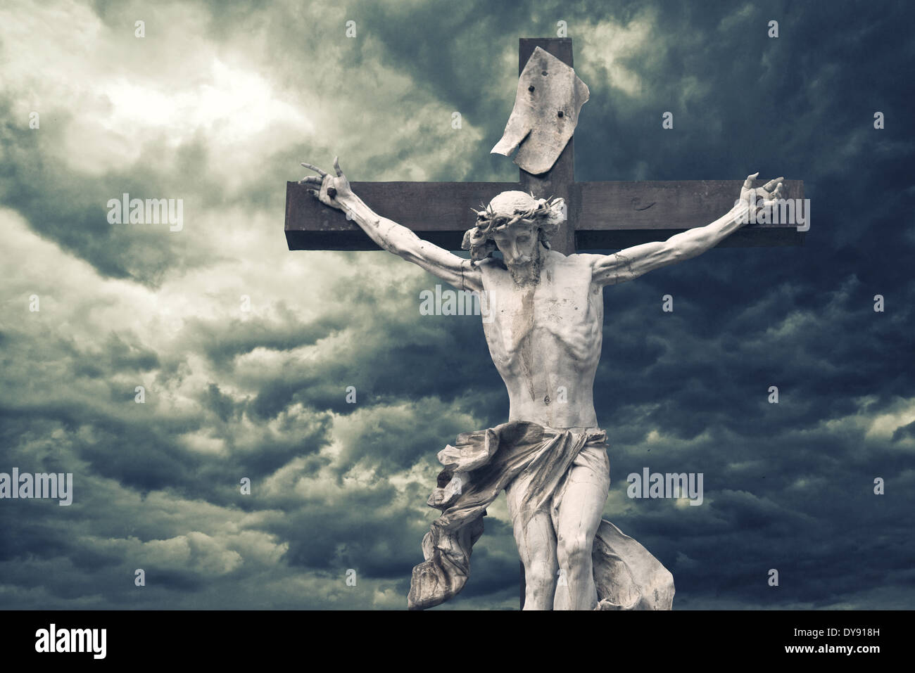 Crucifixion. Christian cross with Jesus Christ statue over stormy clouds. religion and ...