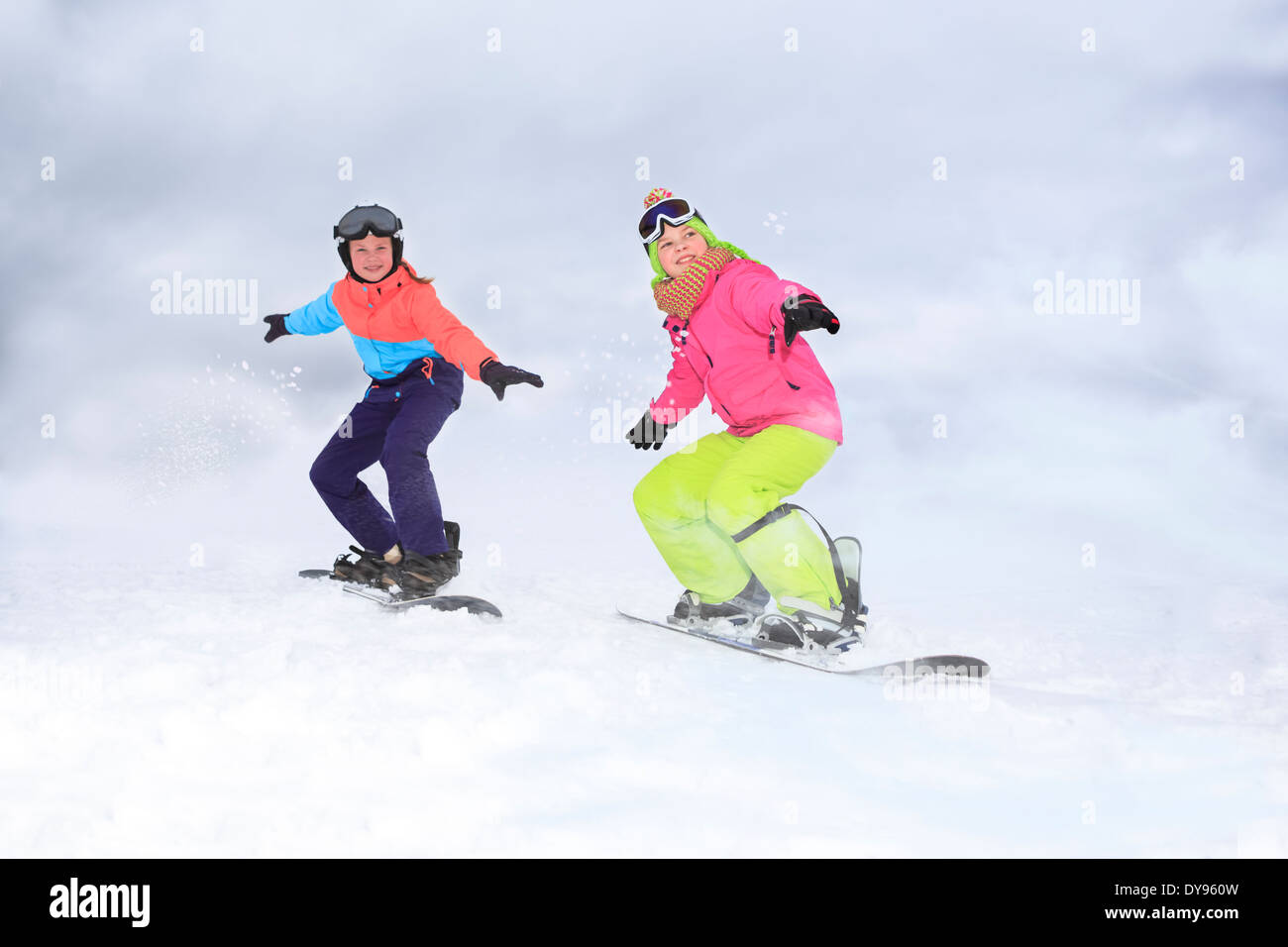 Two happy teenage girls snowboarding Stock Photo - Alamy