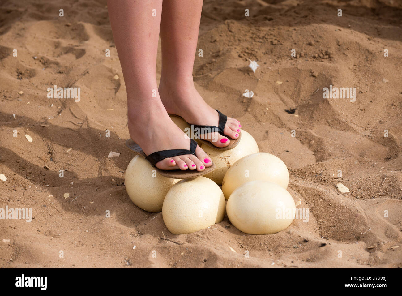 Southern African woman with painted toenails standing on a clutch of ...