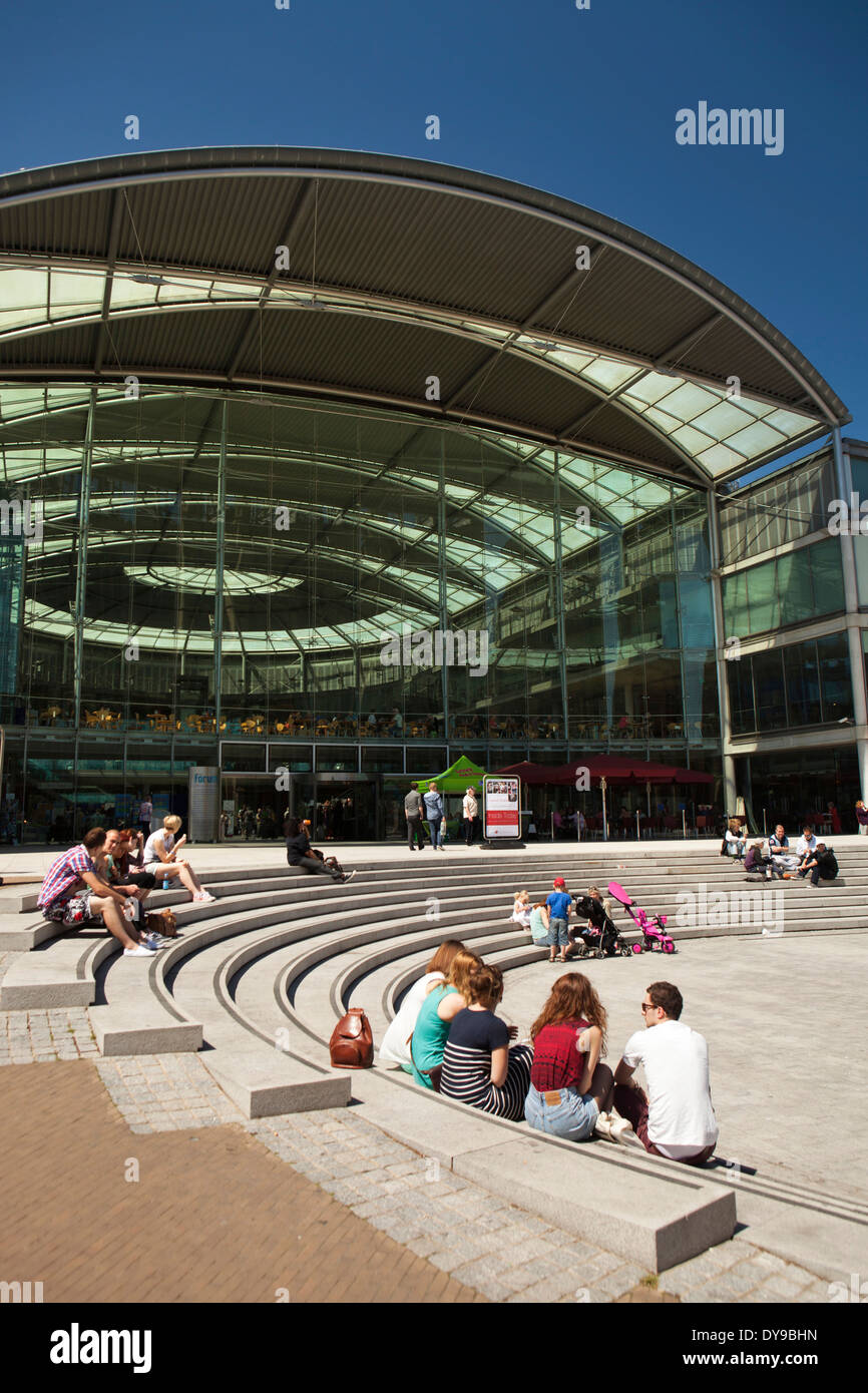 UK, England, Norfolk, Norwich, people sat in sunshine outside The Forum ...