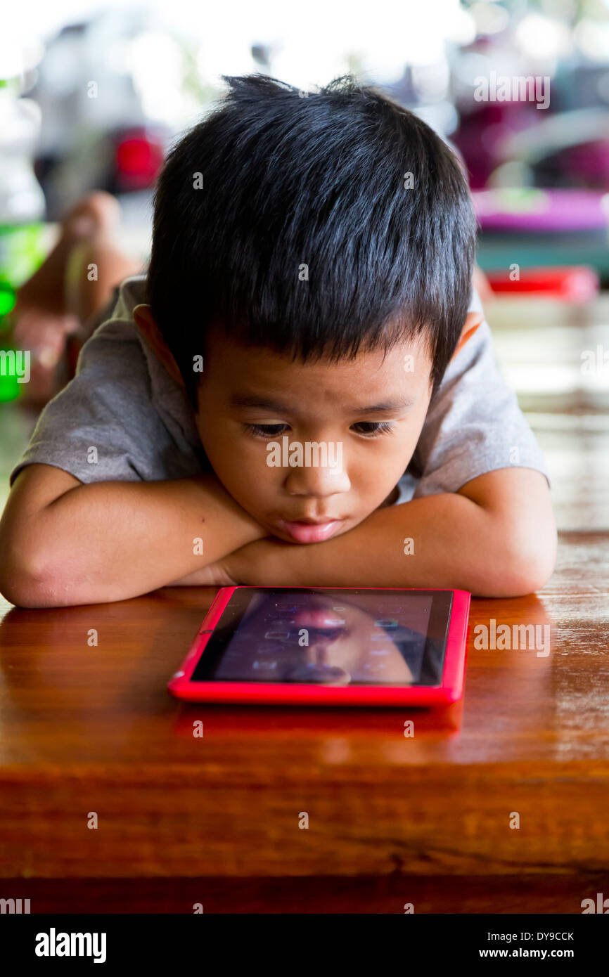 Little Boy playing with a Tablet Computer in the Fishing Village Salak ...