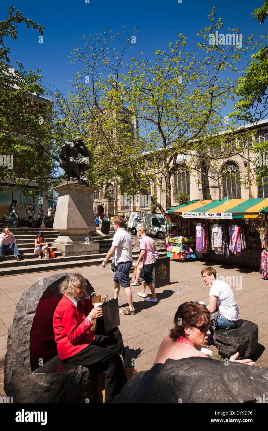 UK, England, Norfolk, Norwich, people sat in sun beside St Peter ...