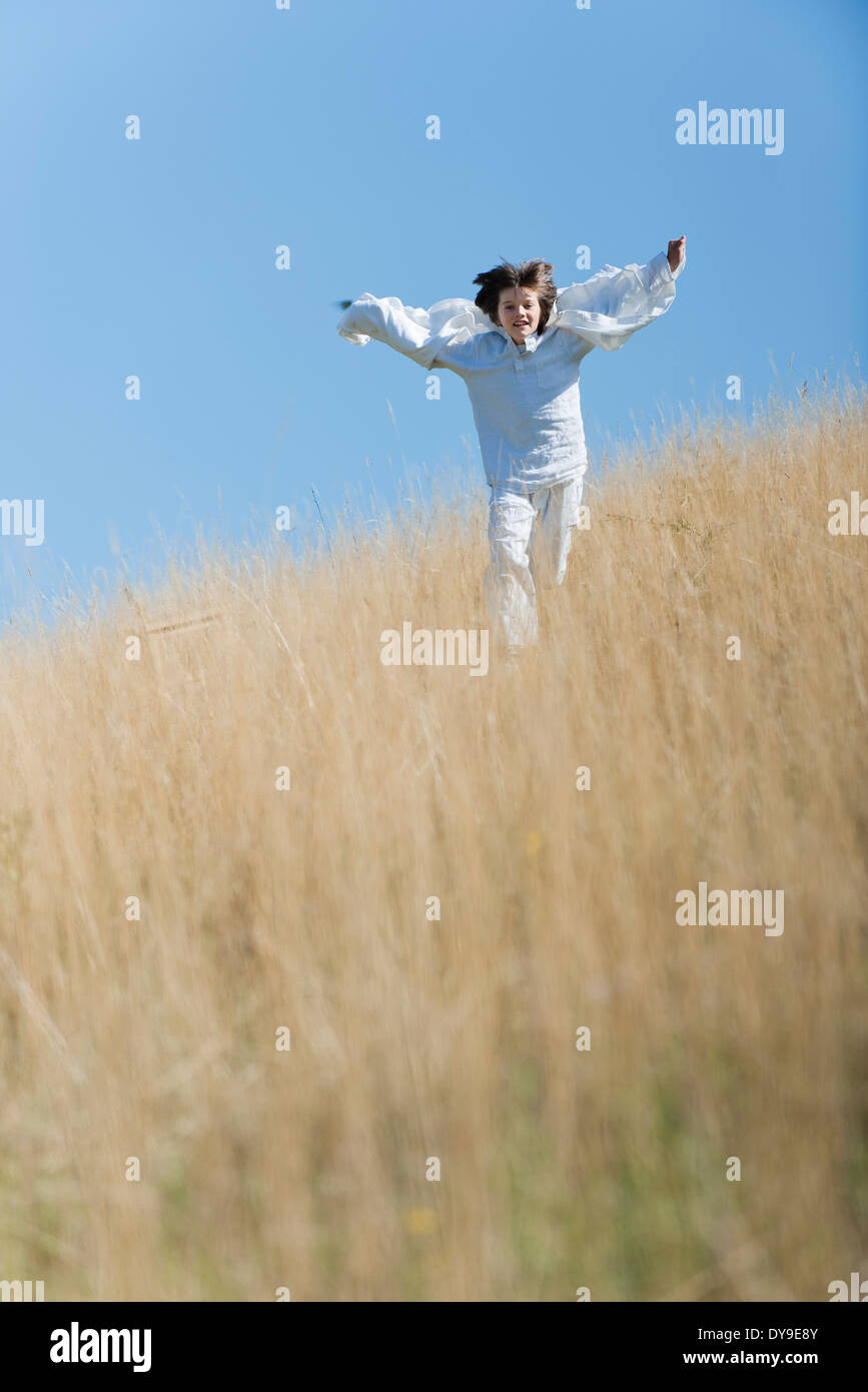 Boy running through tall grass Stock Photo - Alamy