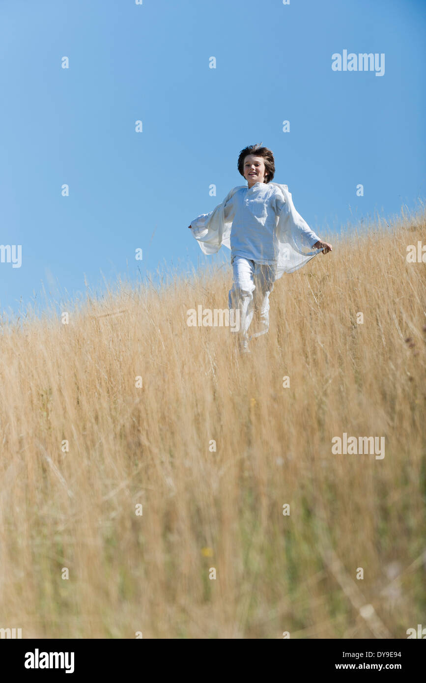 Boy running through tall grass Stock Photo - Alamy