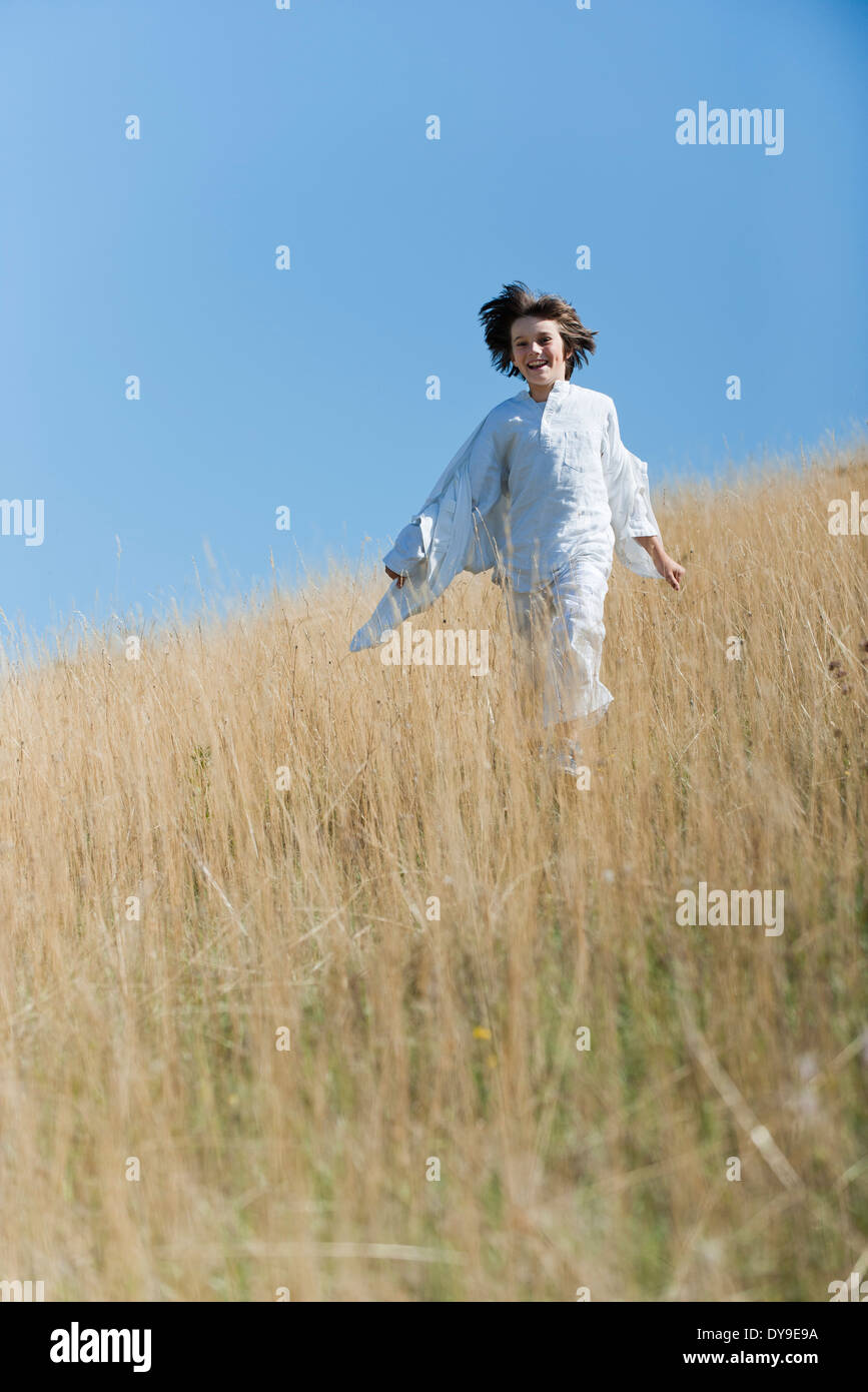 Boy running through tall grass hi-res stock photography and images - Alamy