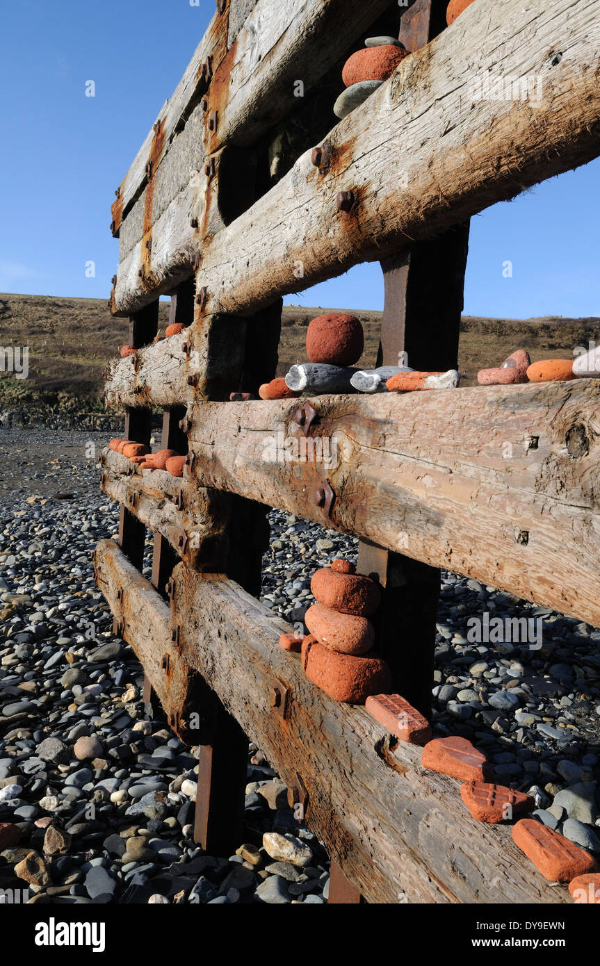 Pebbles and washed up old local bricks on storm damaged sea defence ...