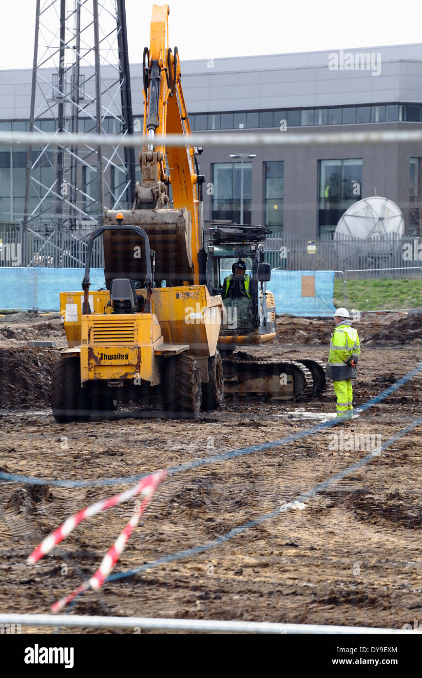 A mechanical digger and dumper truck moving excavated earth on a ...